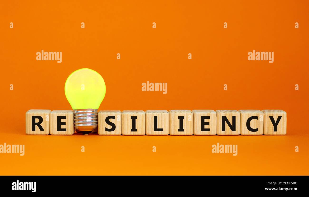 Resiliency symbol. Wooden cubes with word 'resiliency'. Yellow light ...