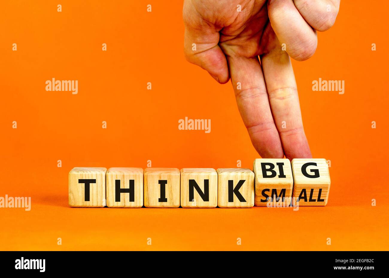 Think small or big concept. Businessman turns wooden cubes, changes ...