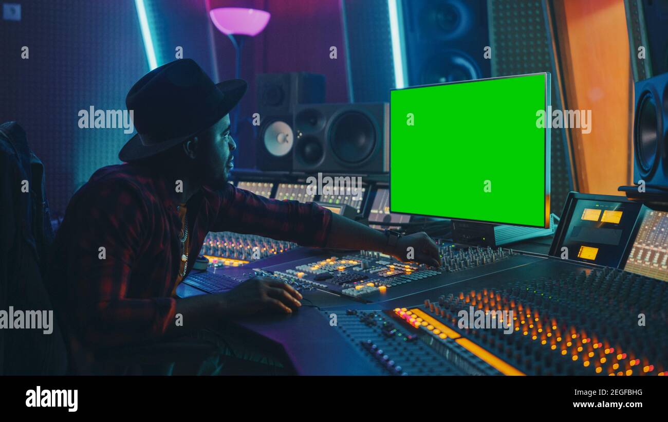 Stylish Audio Producer Working in Music Record Studio, Uses Green ...