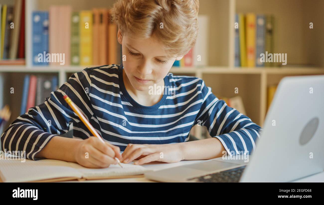 Smart Little Boy Uses Laptop for Learning, Writes Down Useful ...