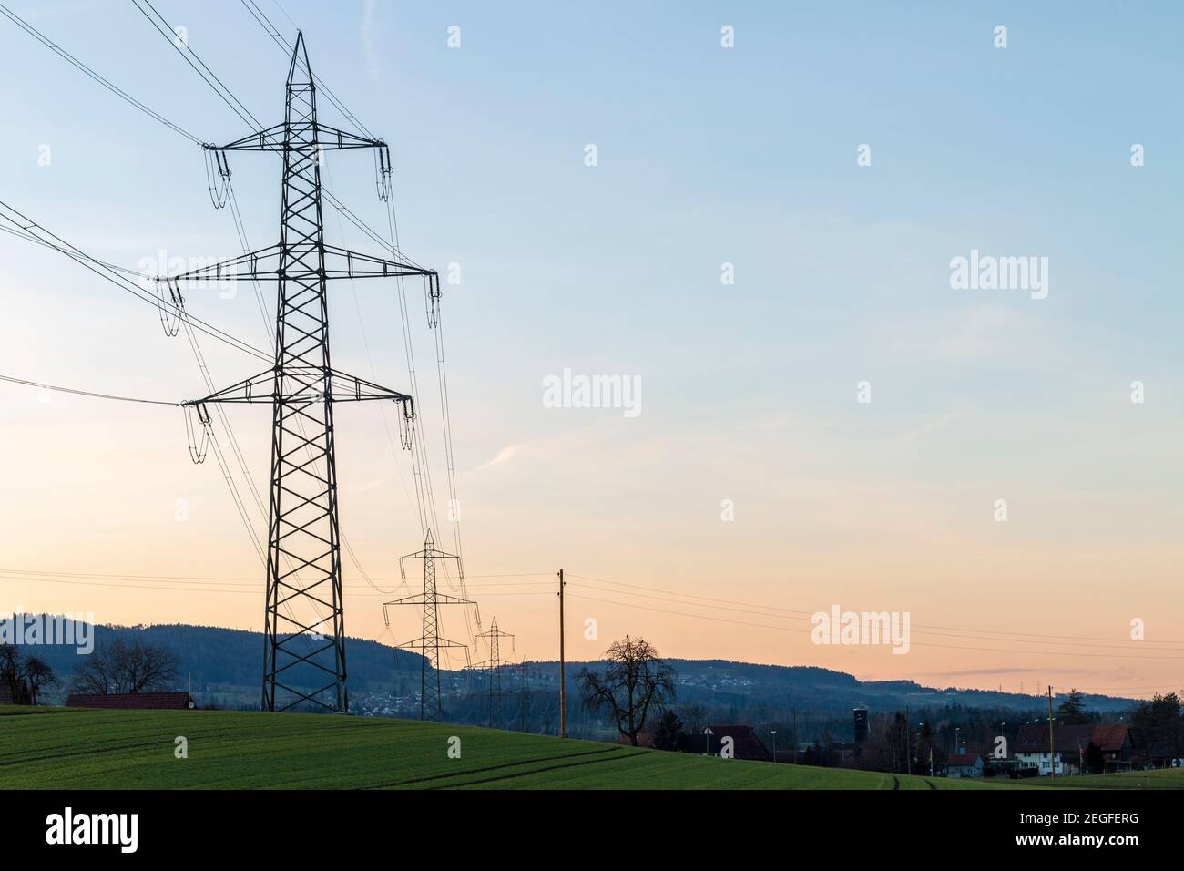 power line on sunset on green field Stock Photo - Alamy