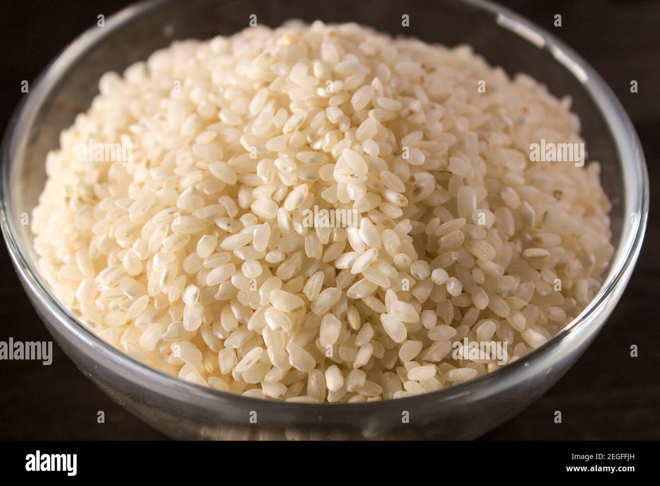 White rice texture and background in glass bowl. Grey background Stock ...