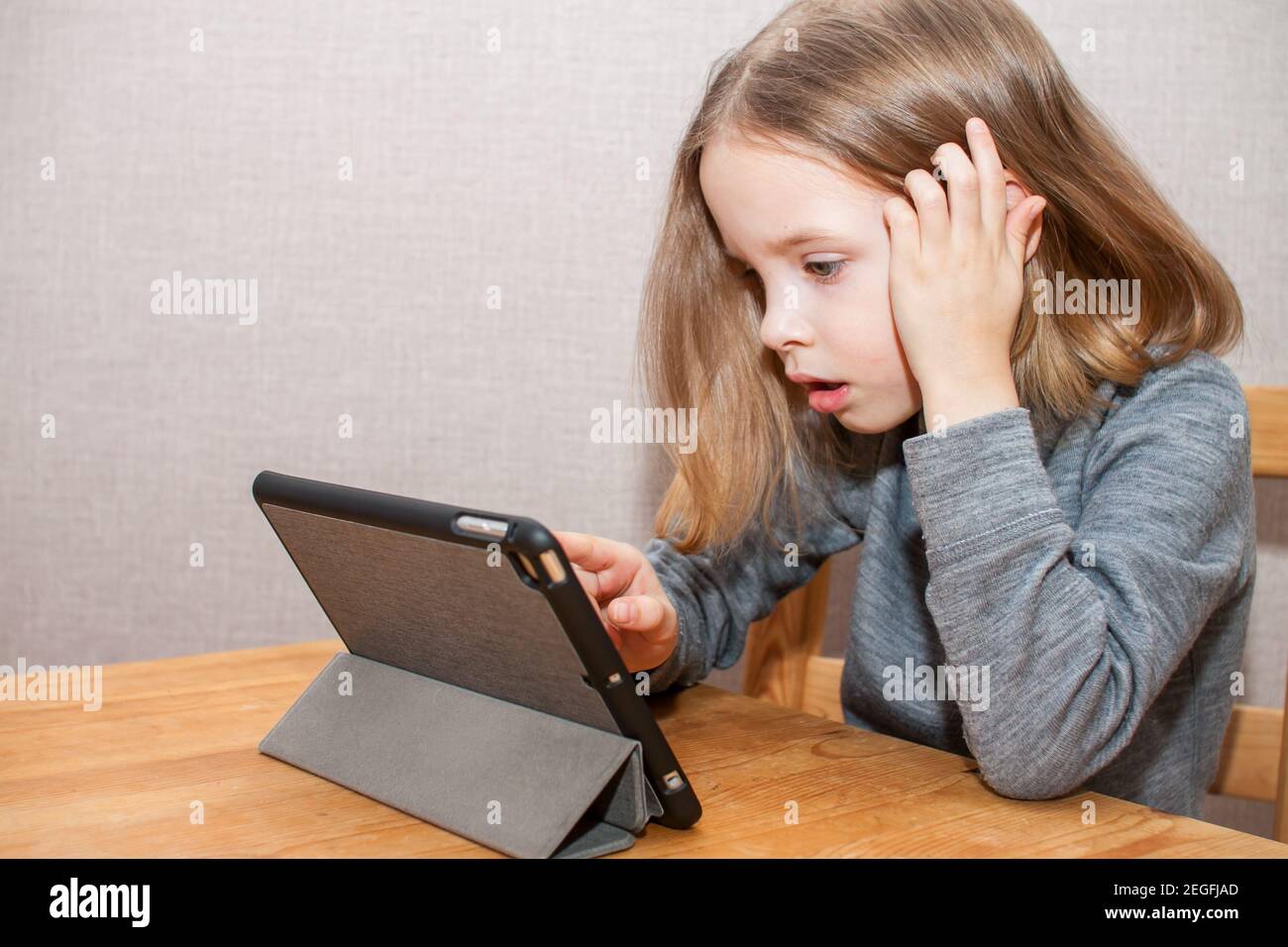 little girl is watching an online video tutorial. Remote training. Blog ...