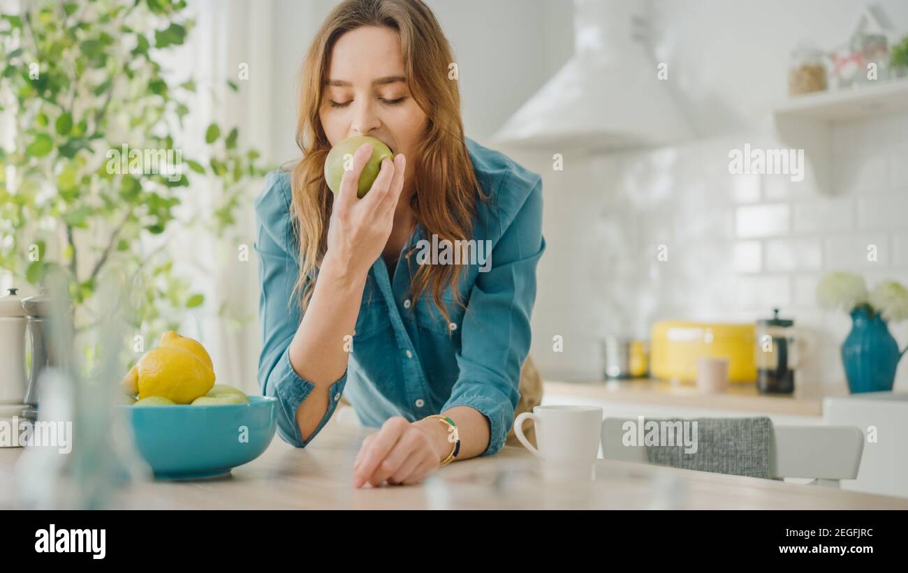 Authentic Beauty Portrait Of A Beautiful Brunette Female Eating A Big Green Apple In A Bright 