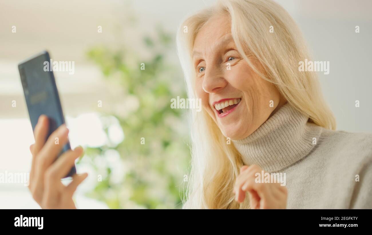 Authentic Senior Woman Answering a Video Call Using Her Smartphone in ...