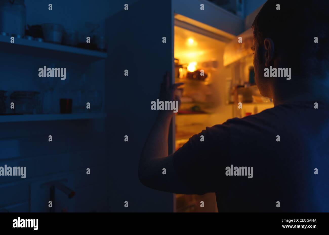 Man looking for food in refrigerator at night Stock Photo - Alamy