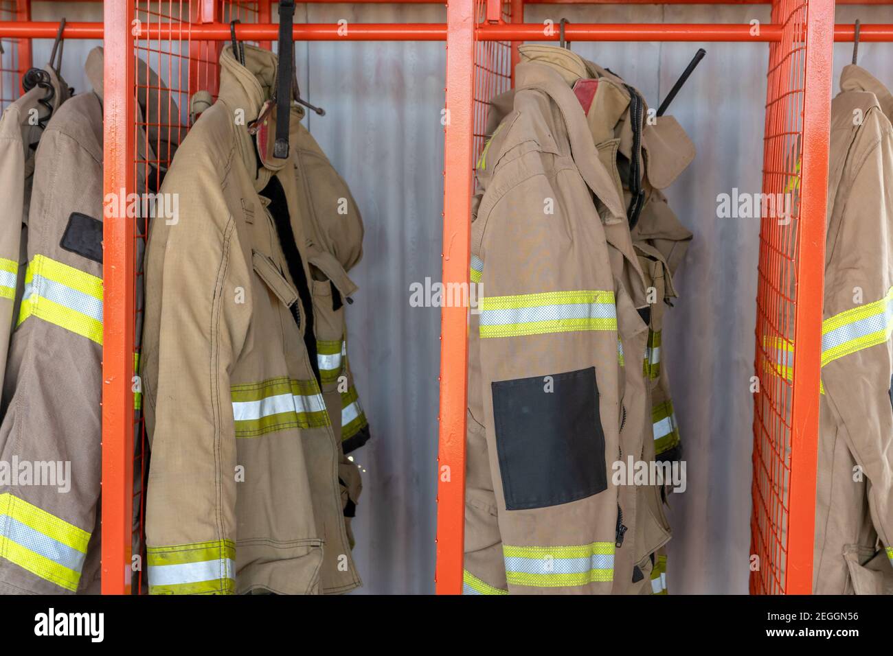 Metal rack with firefighter uniforms in a station Stock Photo - Alamy