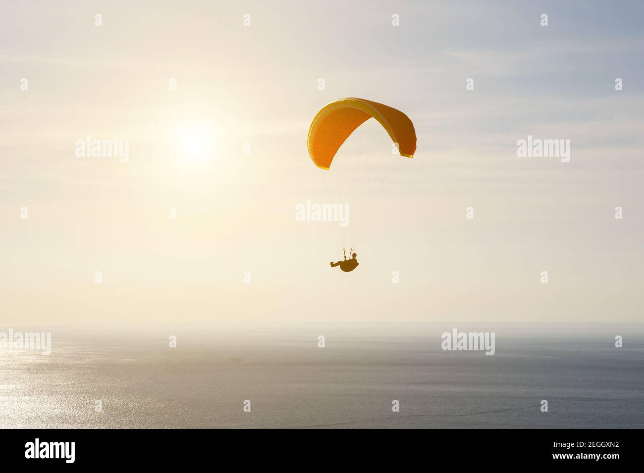 Man on a paraglider, silhouette, flight over the sea Stock Photo - Alamy