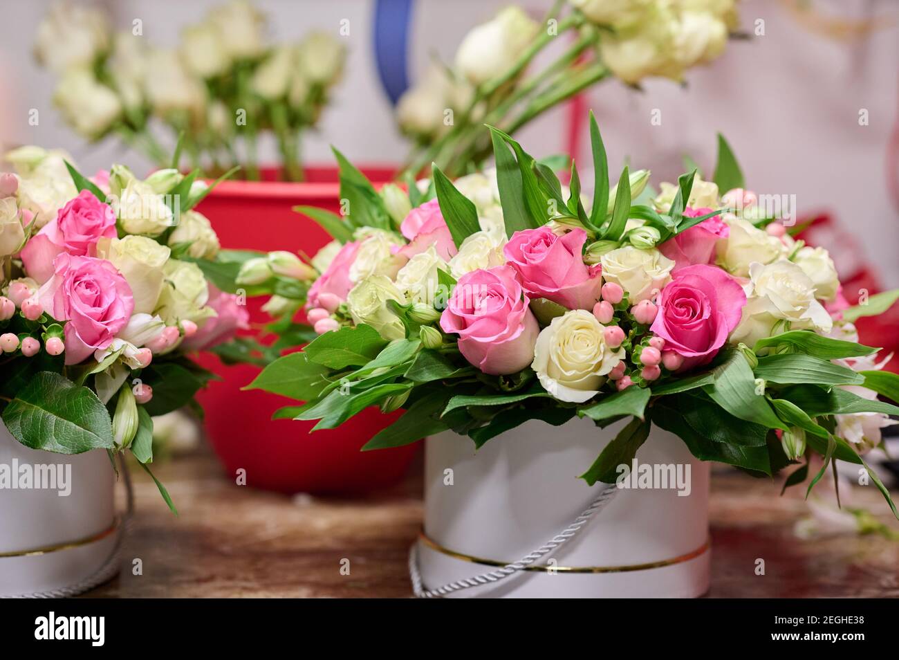 Florist making a flower box with pink and white roses, white roses in a ...