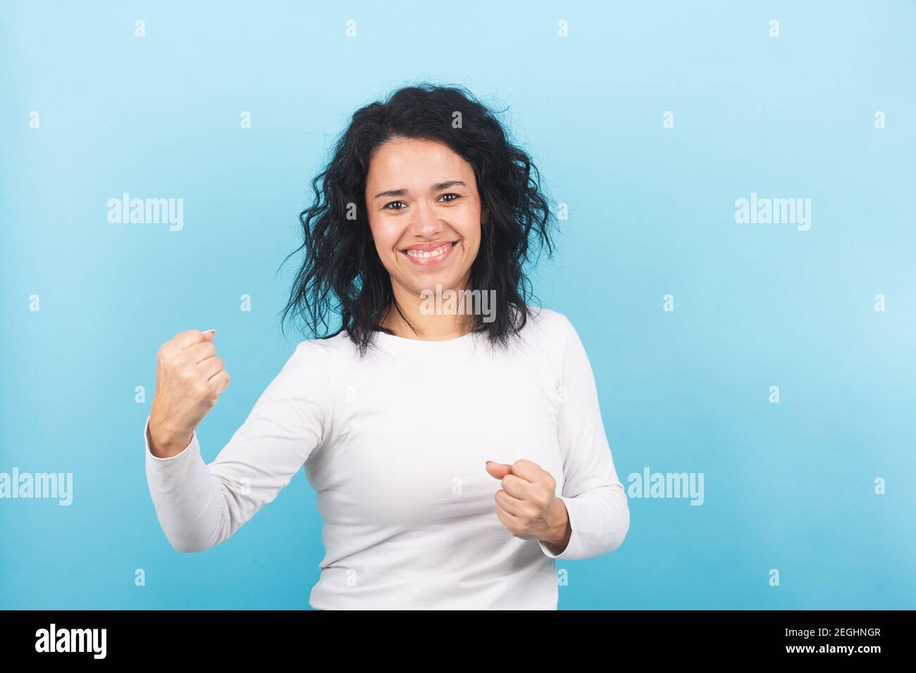 Young brunette woman looks euphoric and celebrates victory Stock Photo ...