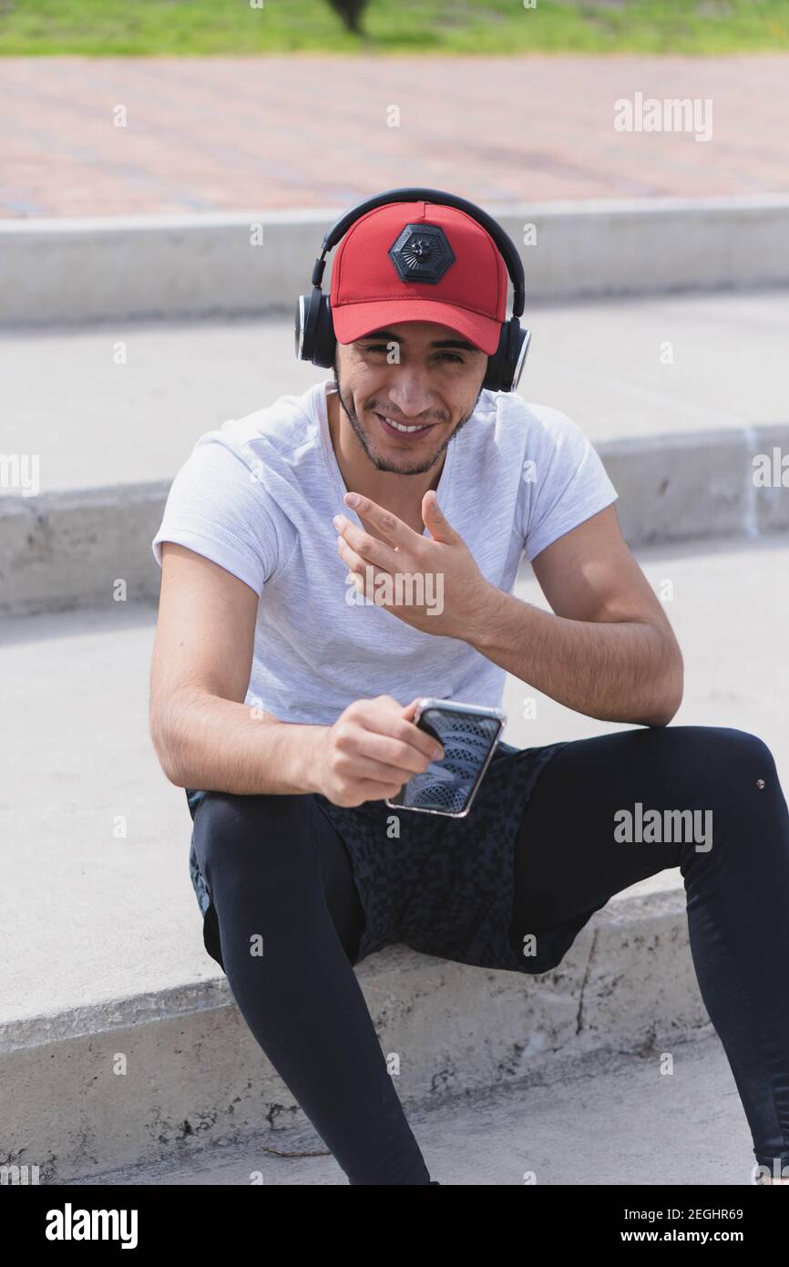 Young man listening to music to perform different exercises and get ...