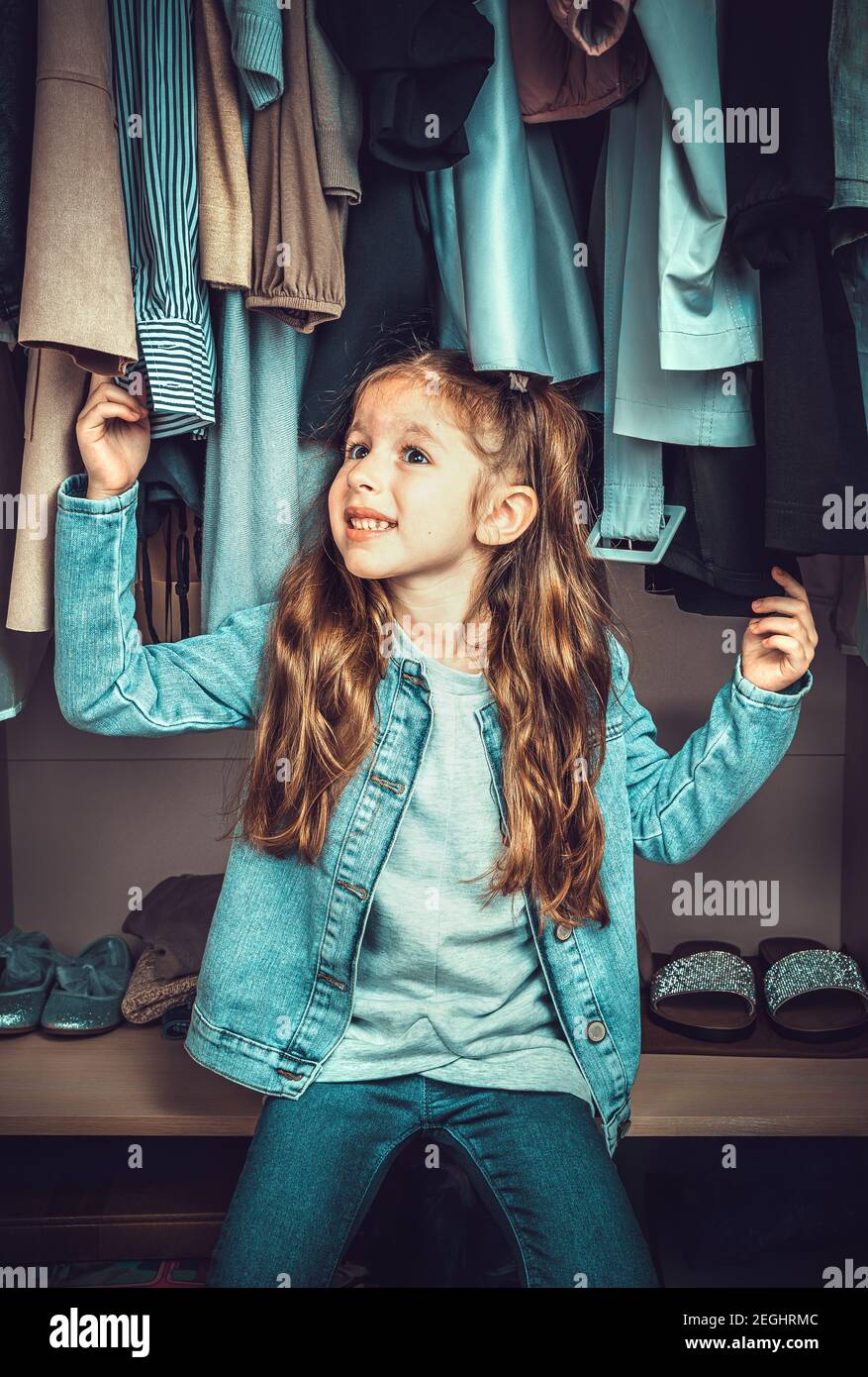 Funny little girl having fun in the wardrobe with clothes Stock Photo ...