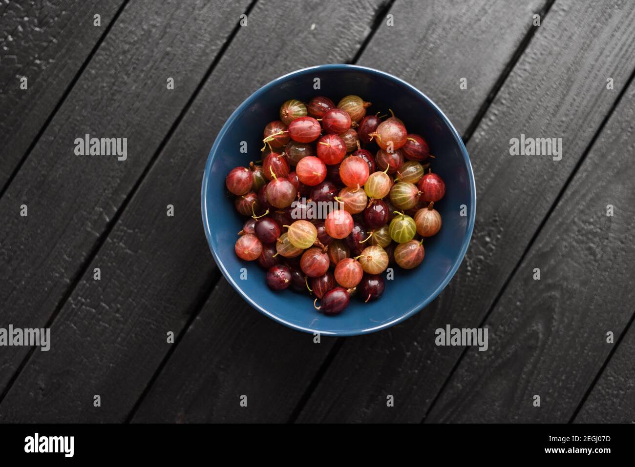 Organic berries. Healthy snack. Raw pink and green gooseberries in blue ...