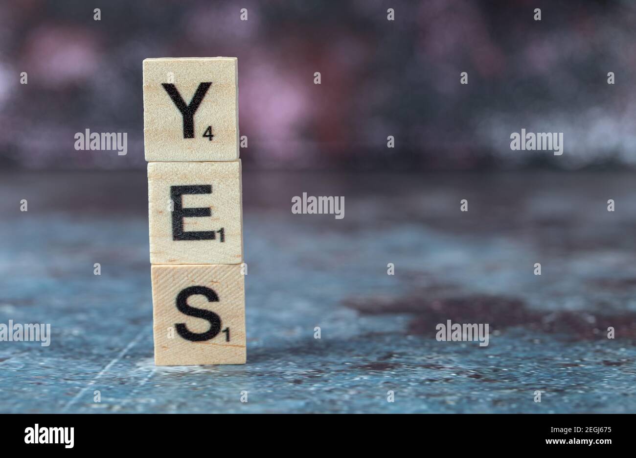 Yes symbolic writing with black letters on wooden dices in vertical ...