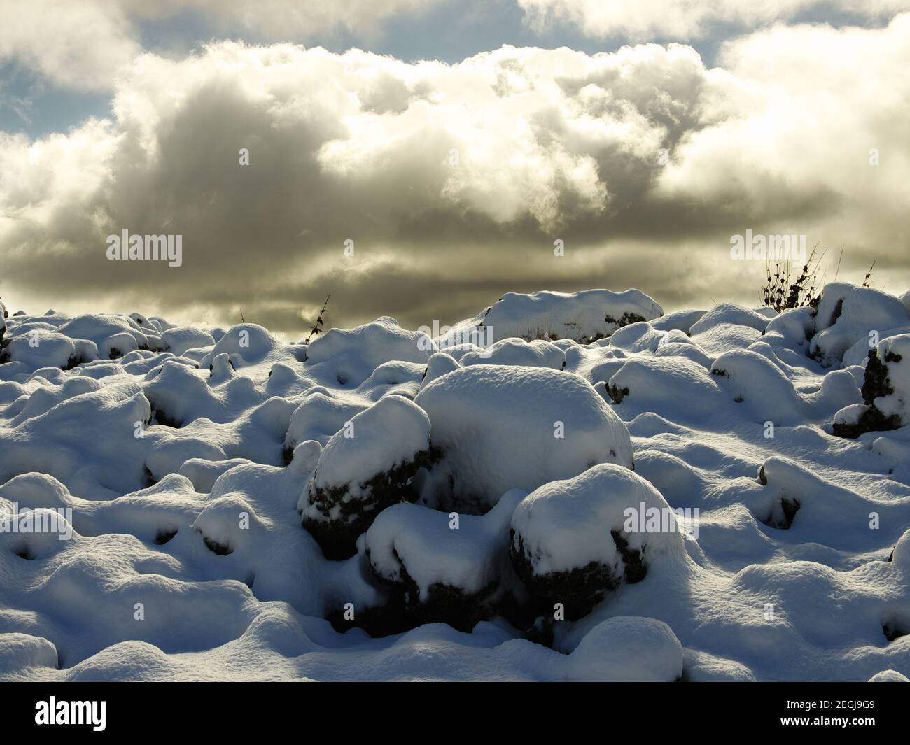 cold lava covered by snow on background clouds Stock Photo - Alamy