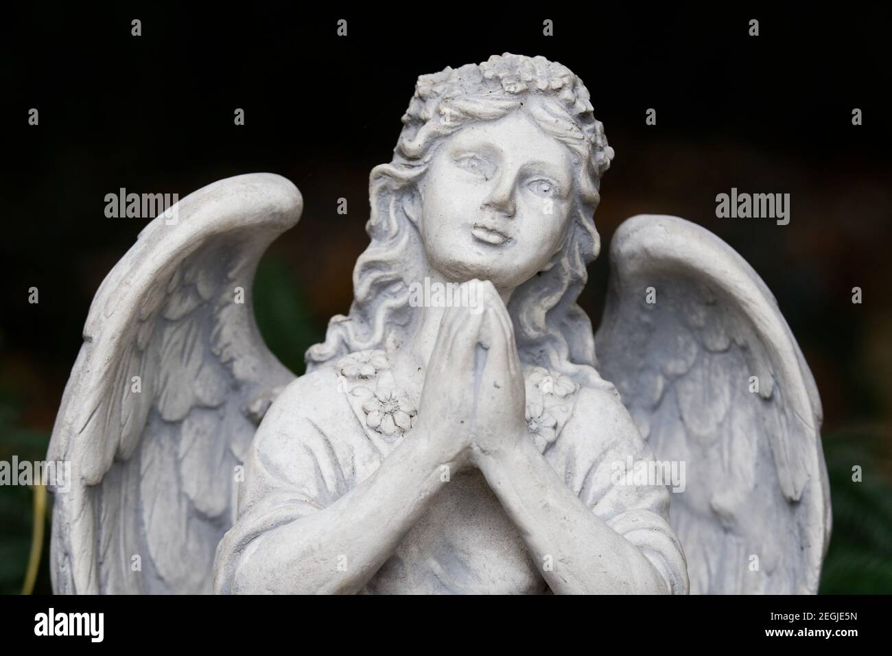 praying angel figure against black background in a cemetery Stock Photo ...