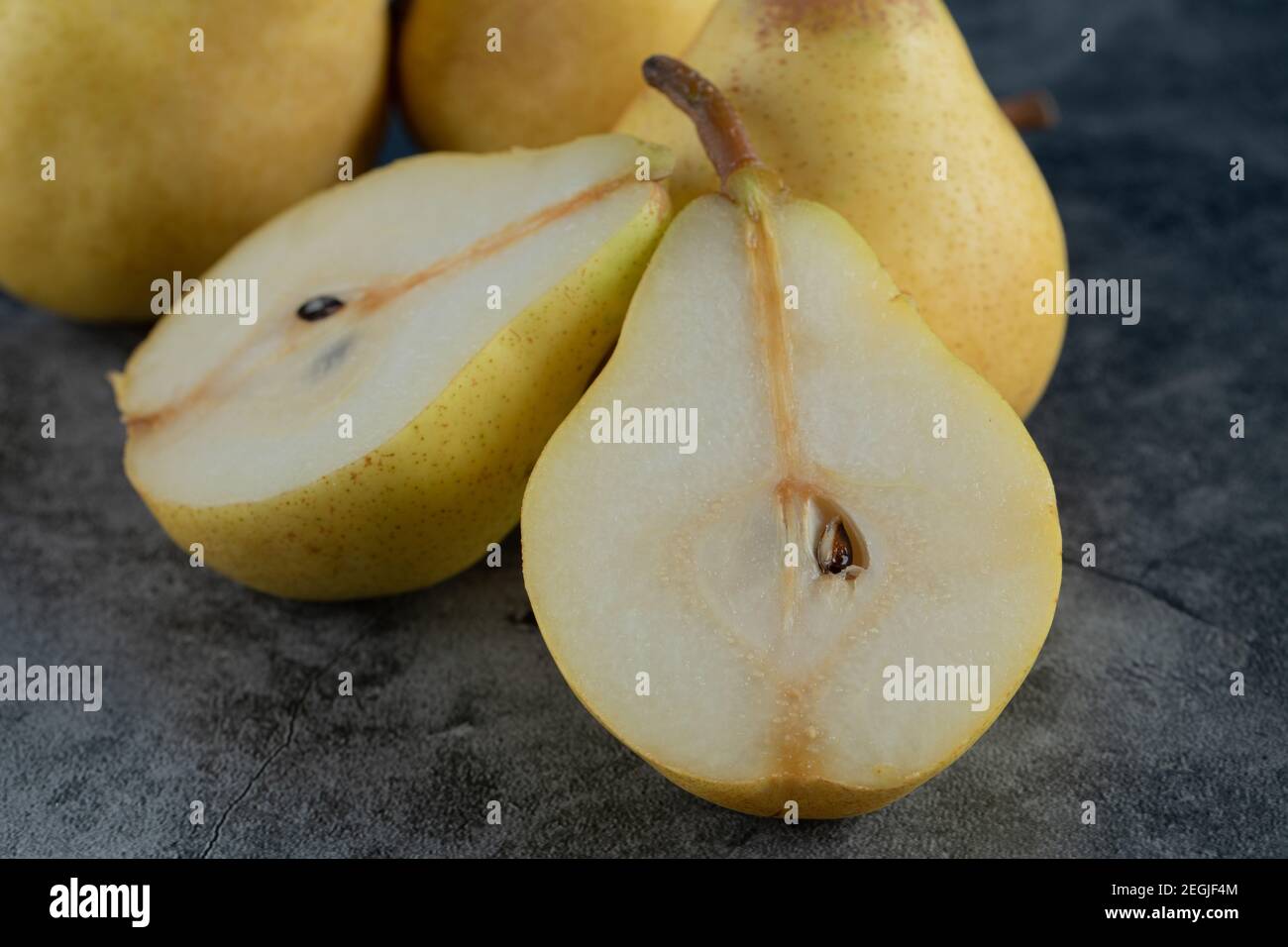 Whole and half cut yellow pears on the grey marble background Stock ...