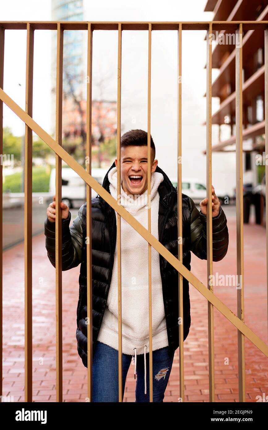 Young guy standing behind a metal fence while looking camera Stock ...