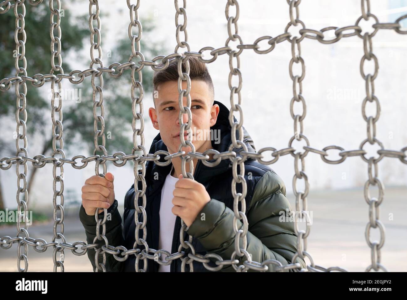 Young guy standing behind a metal fence while looking camera Stock ...