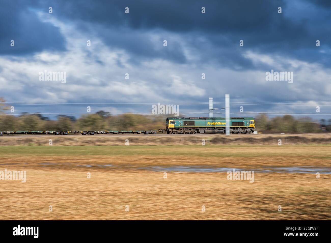 Freightliner 66519 is panned near Hullavington with an empty container ...