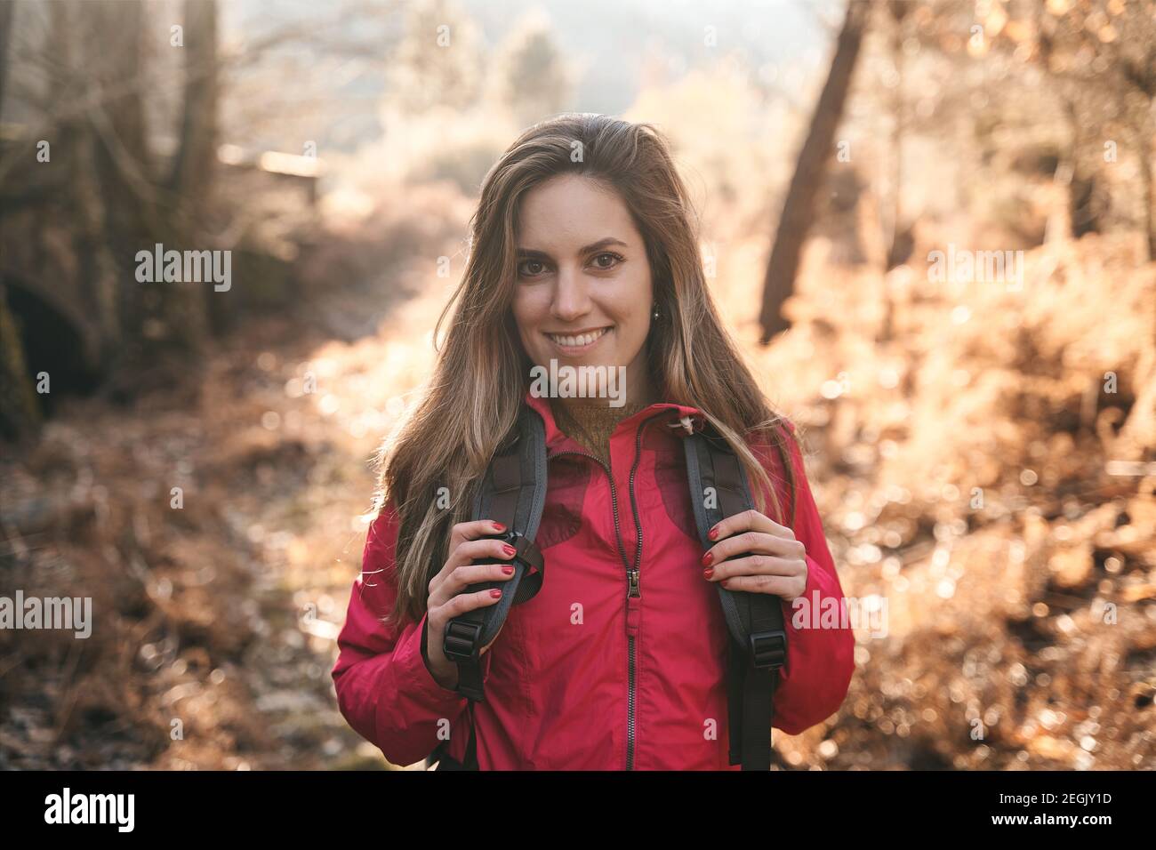 close-up of pretty and adventurous girl smiling in the forest while ...