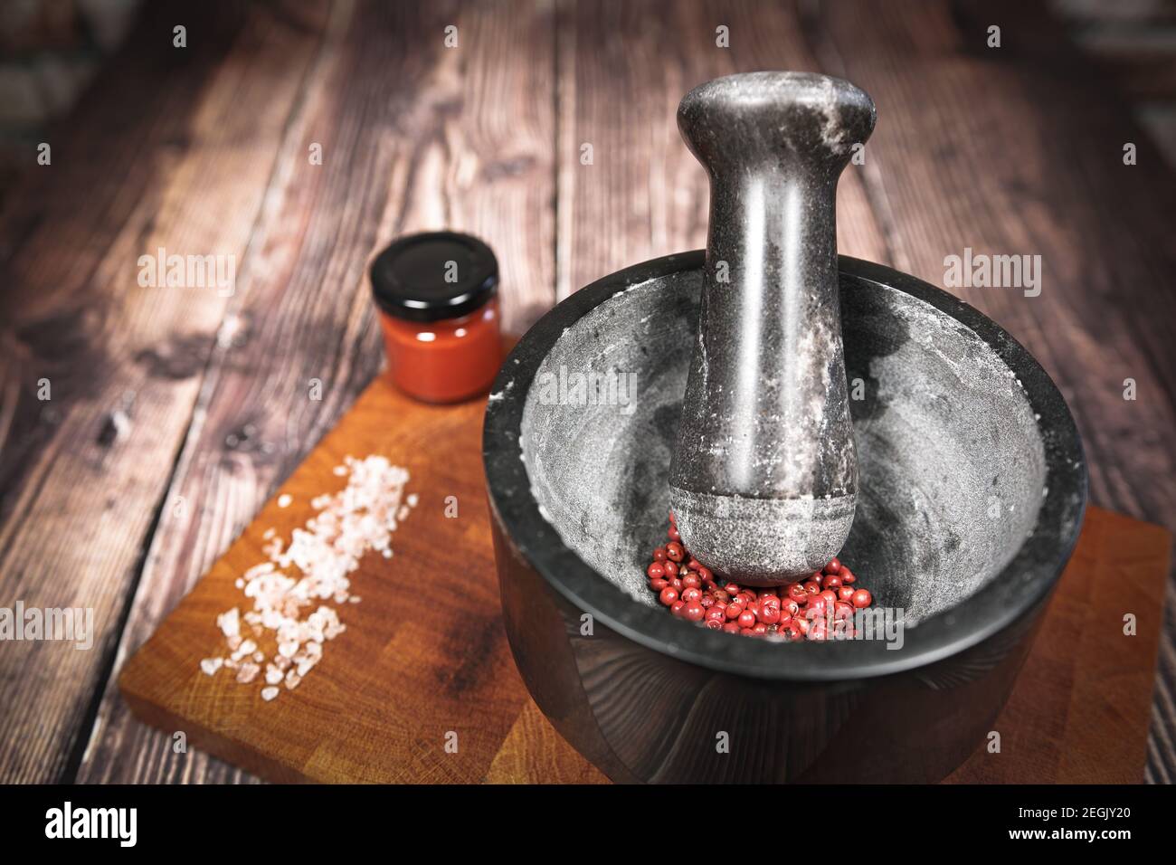 Kitchen mortar with red berries on a wooden board Stock Photo - Alamy