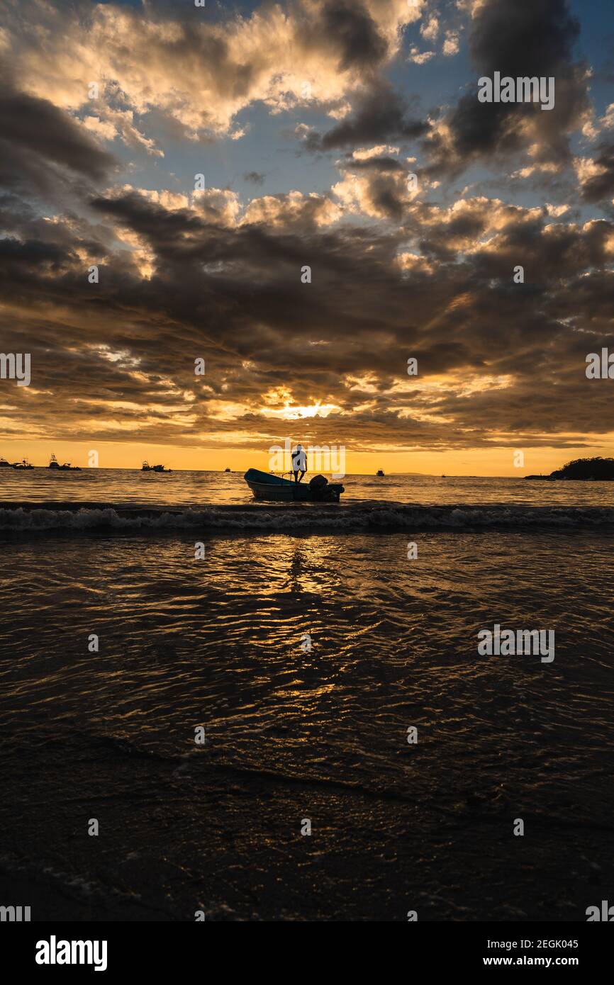Man standing in his boat watches the sunset Stock Photo - Alamy