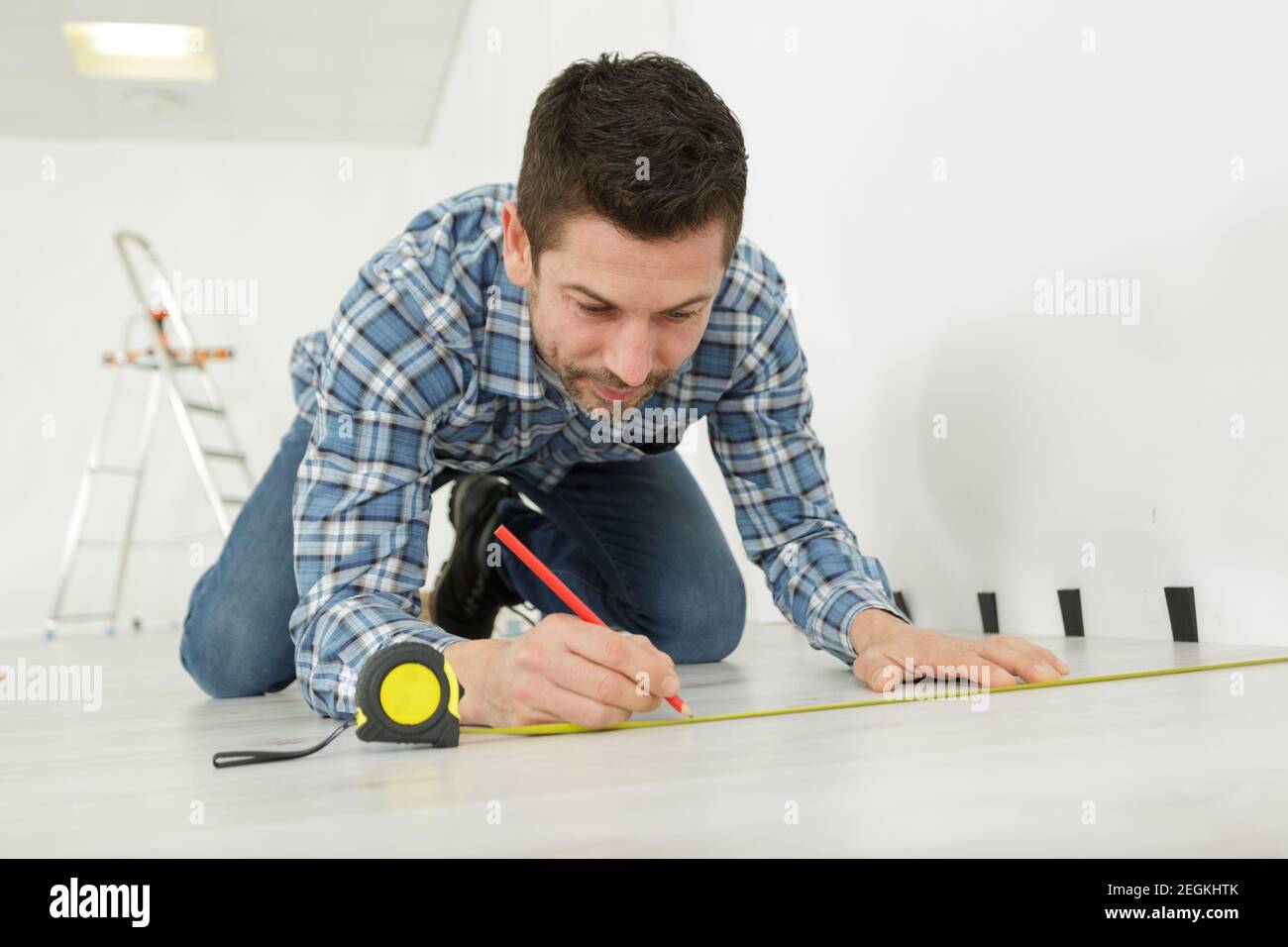 man measuring wooden floor with tape measure Stock Photo - Alamy