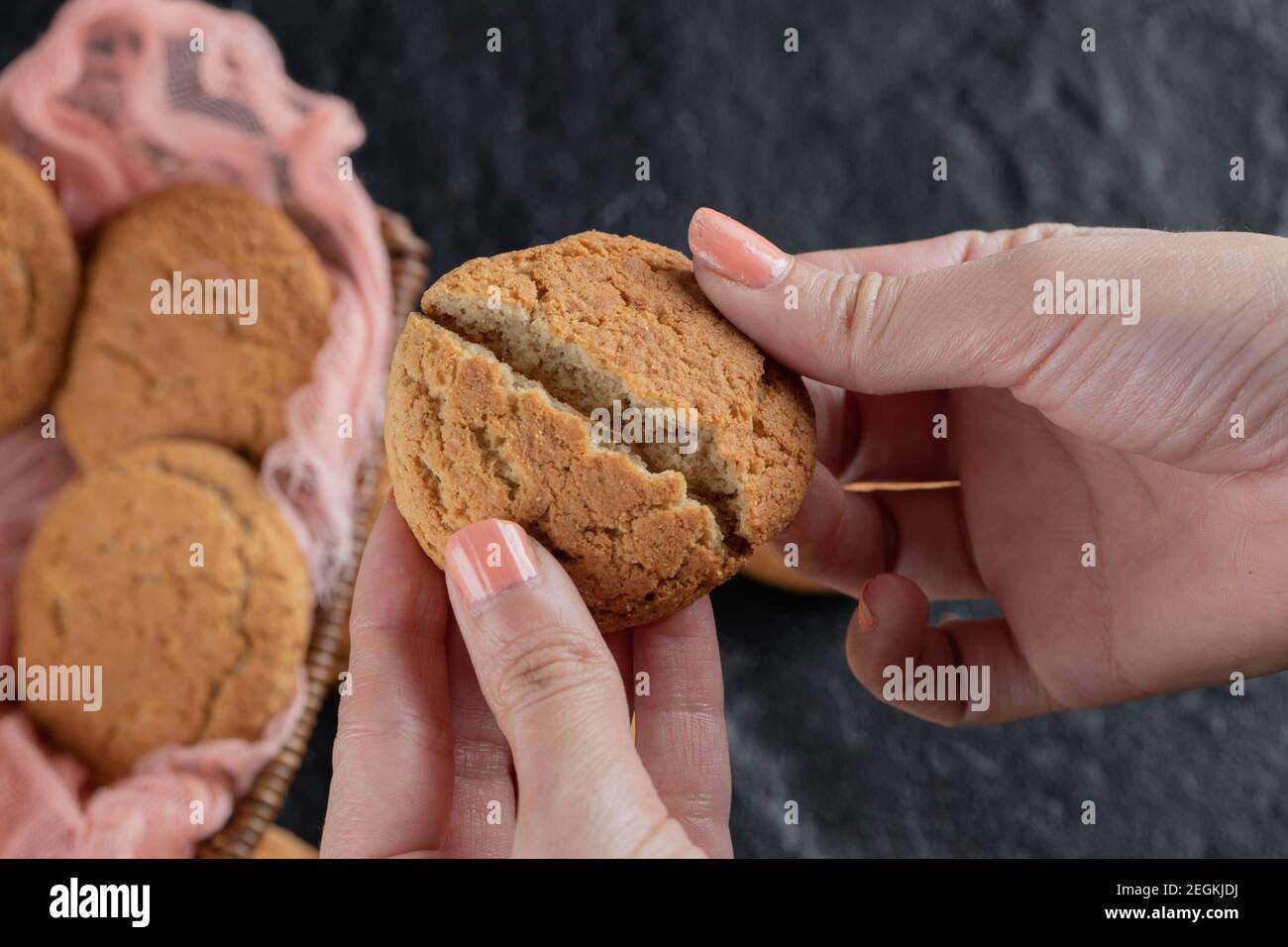 Cutting crispy oatmeal cookie into half in the hand Stock Photo - Alamy