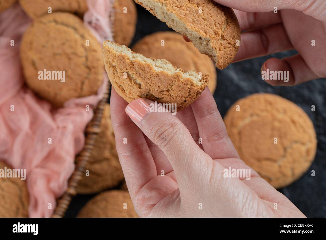 Cutting crispy oatmeal cookie into half in the hand Stock Photo - Alamy