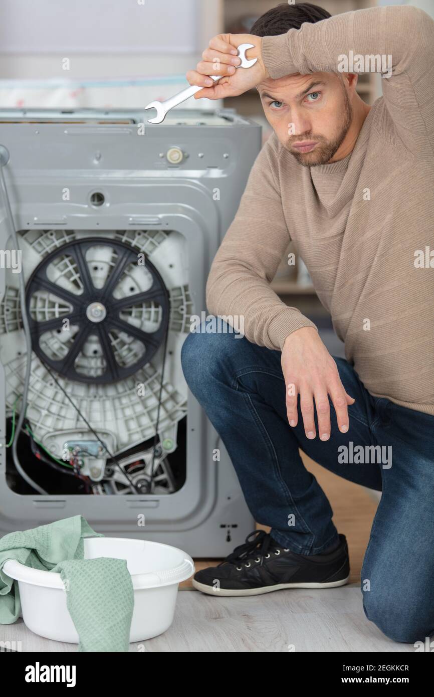 working man plumber repairing a washing machine Stock Photo - Alamy