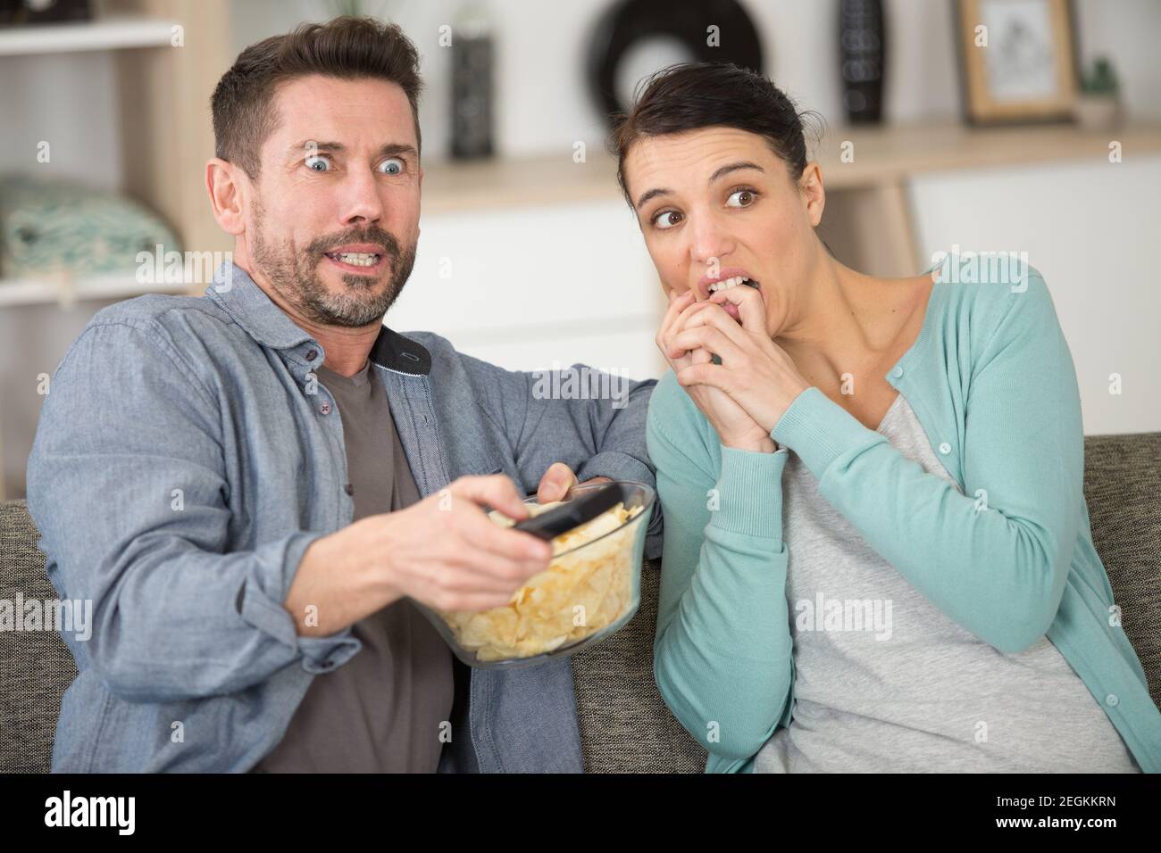 scared couple watching a horror movie Stock Photo - Alamy