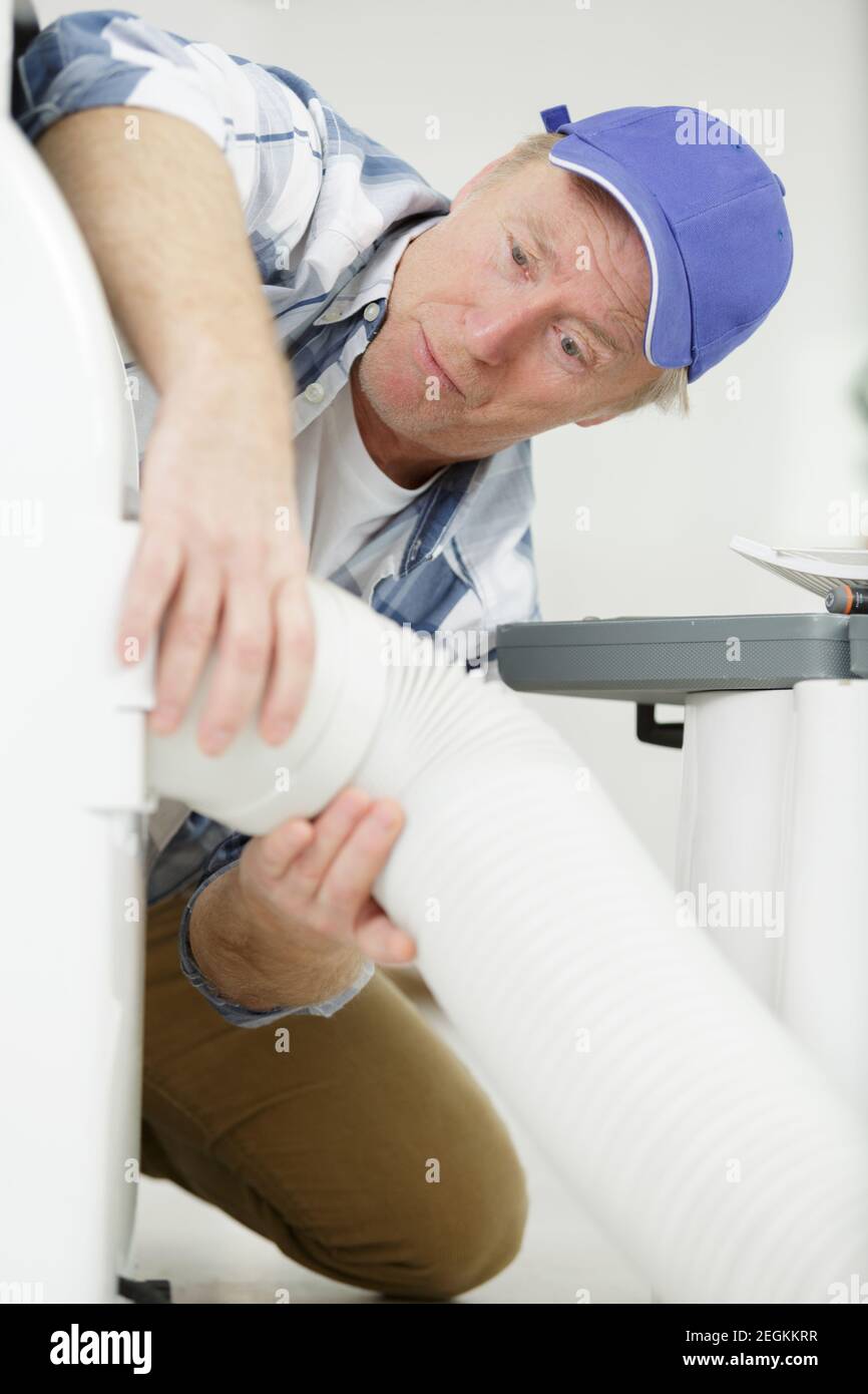 man holding flexible hose in roofspace Stock Photo - Alamy