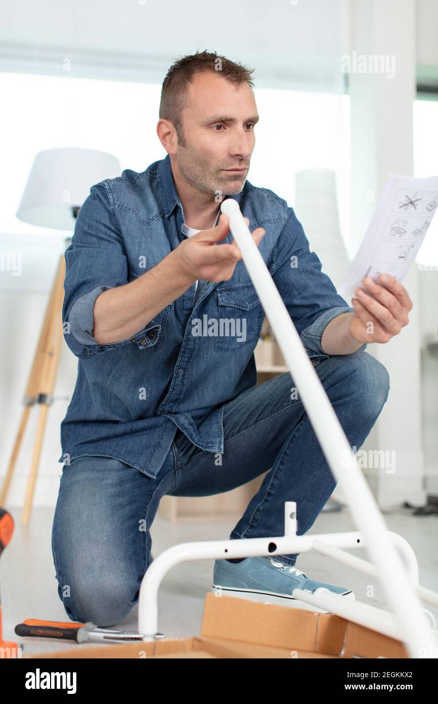 man putting together self assembly furniture Stock Photo - Alamy