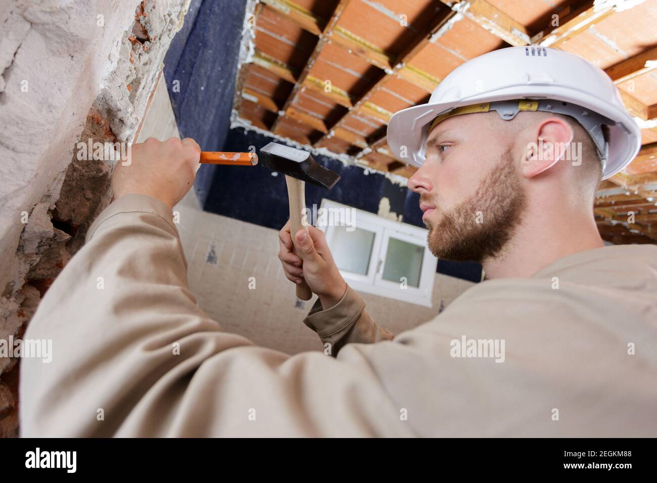 young male builder using hammer chisel Stock Photo - Alamy