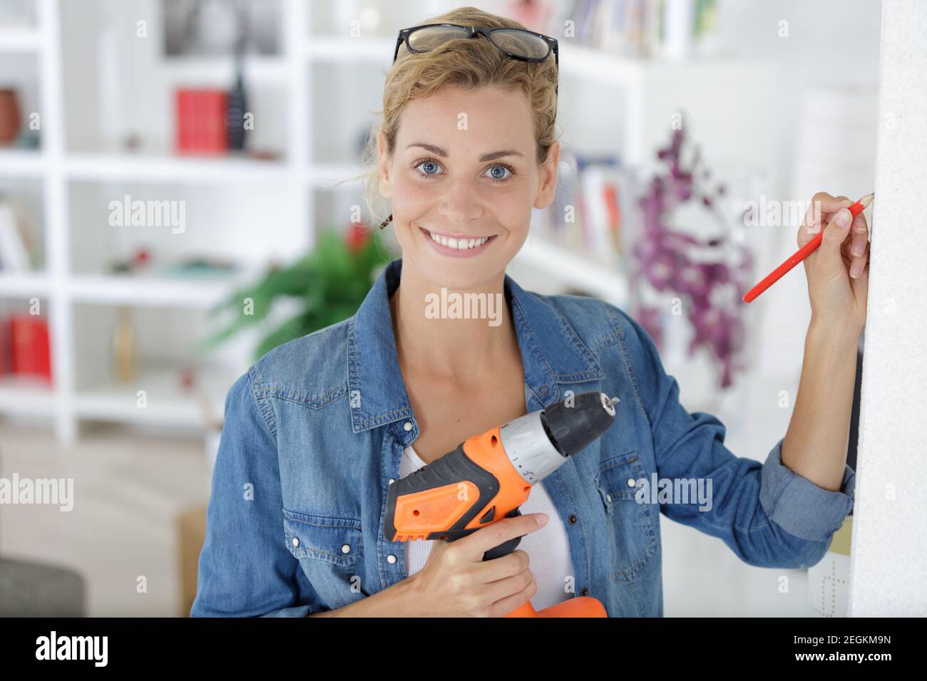 attractive woman using a drill in the home Stock Photo - Alamy