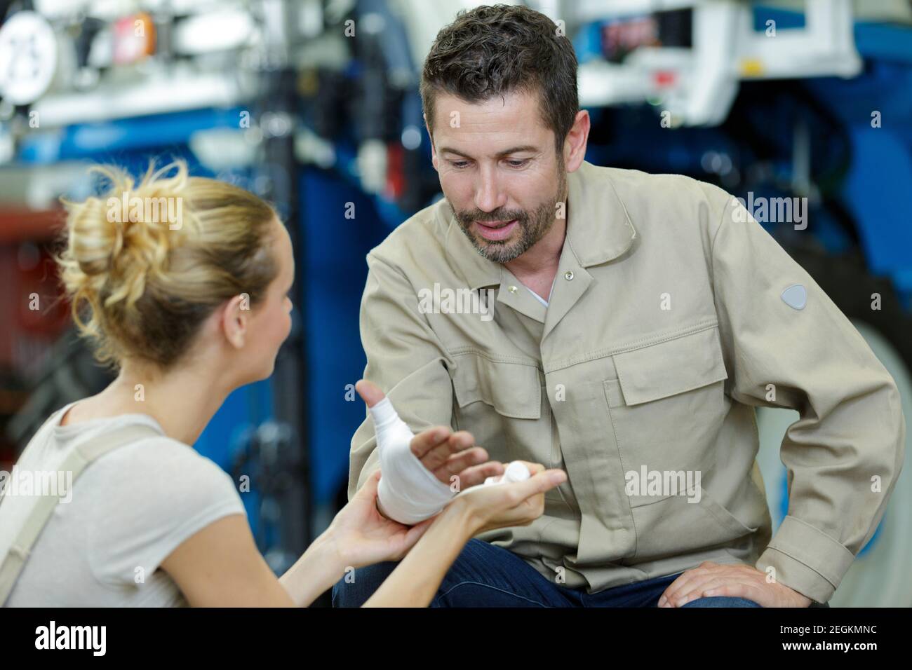 female colleague helping male injured worker Stock Photo - Alamy