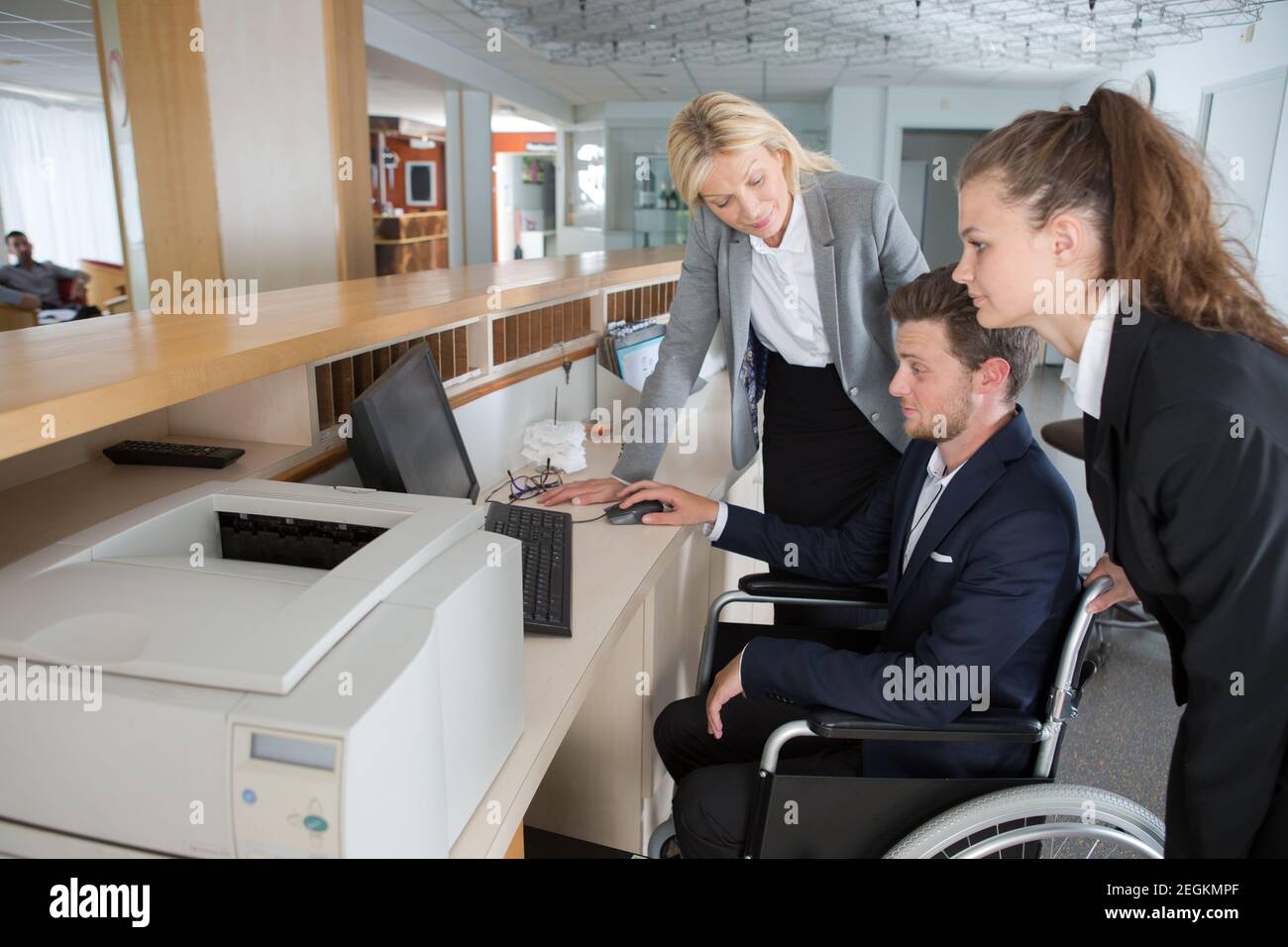 man in a wheelchair working at a hotel reception Stock Photo - Alamy