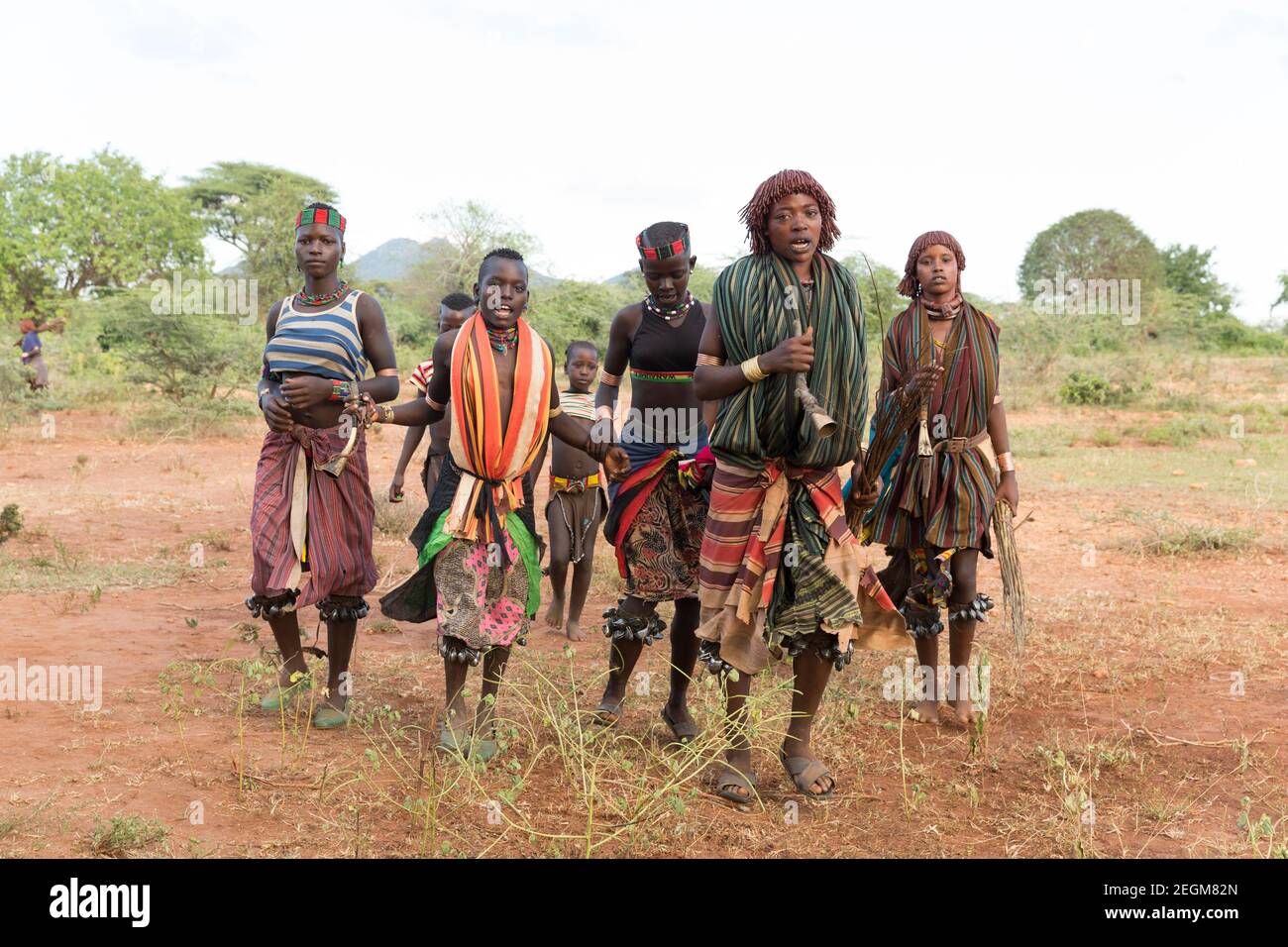 Women from the Banna tribe dancing and blowing little horns before a ...