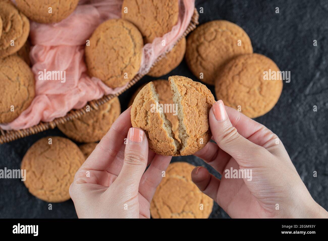 Cutting crispy oatmeal cookie into half in the hand Stock Photo - Alamy