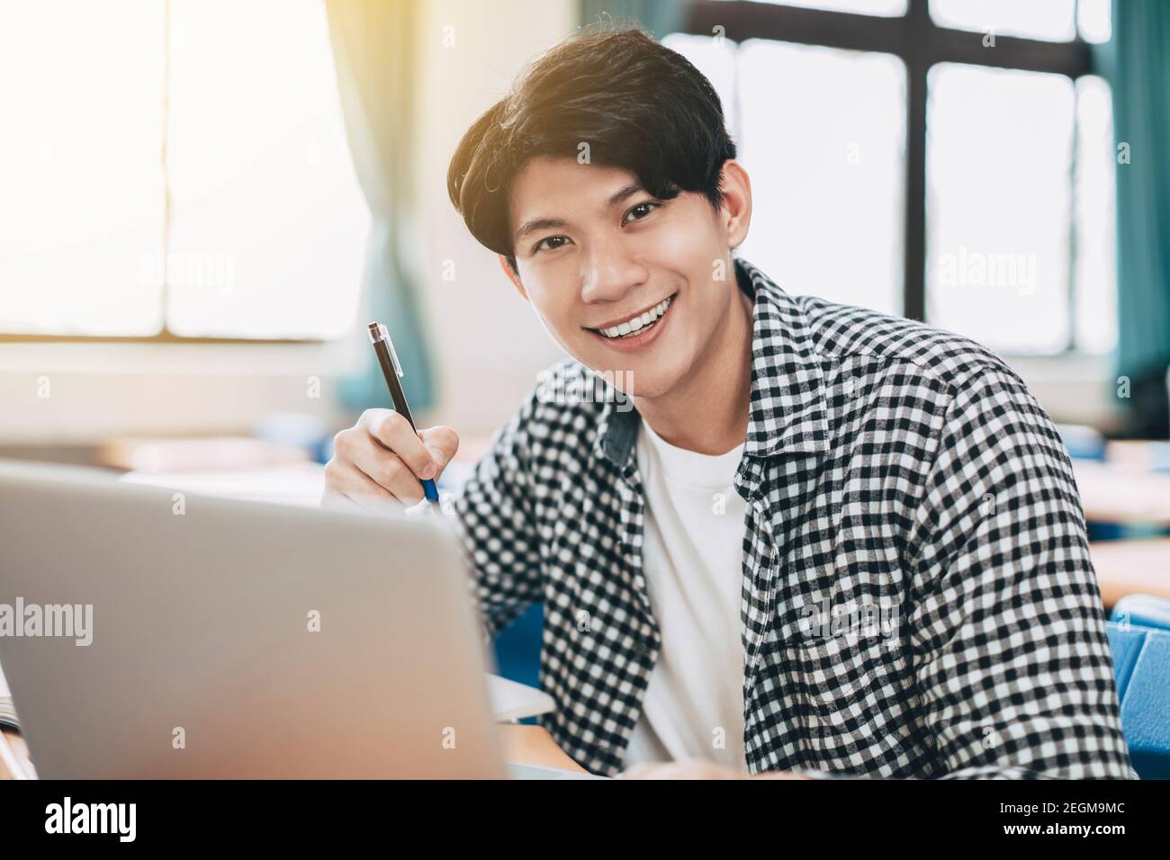 Young cheerful asian student studying in classroom Stock Photo - Alamy