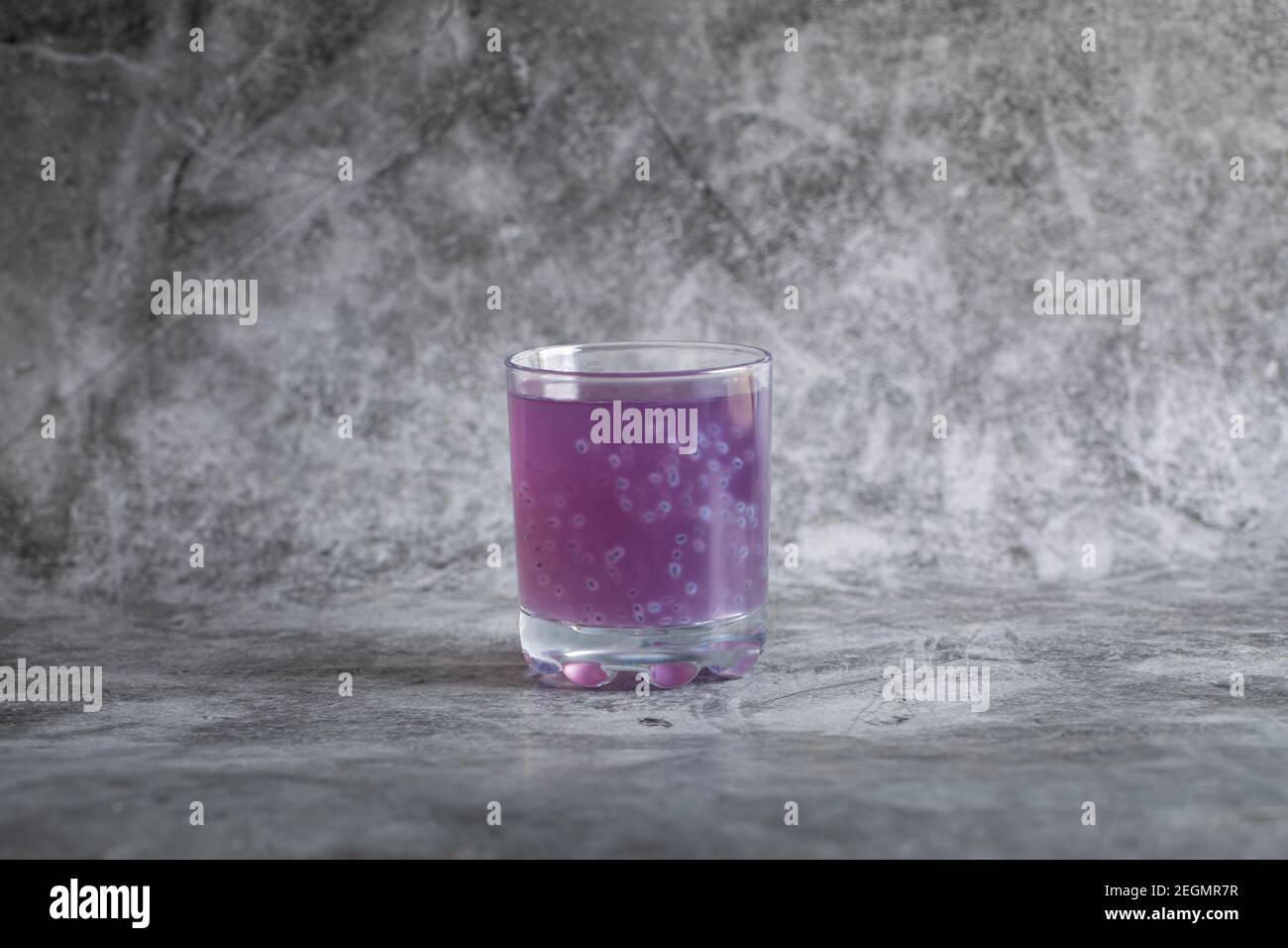 A glass of purple blueberry juice on grey background Stock Photo - Alamy