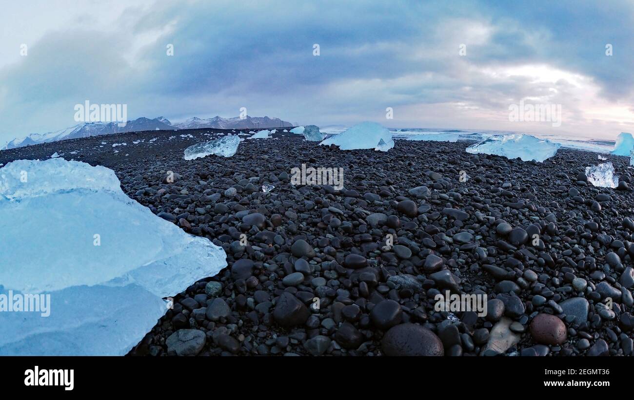 Multiple ice rocks and black rocks over black sand beach at Diamond ...