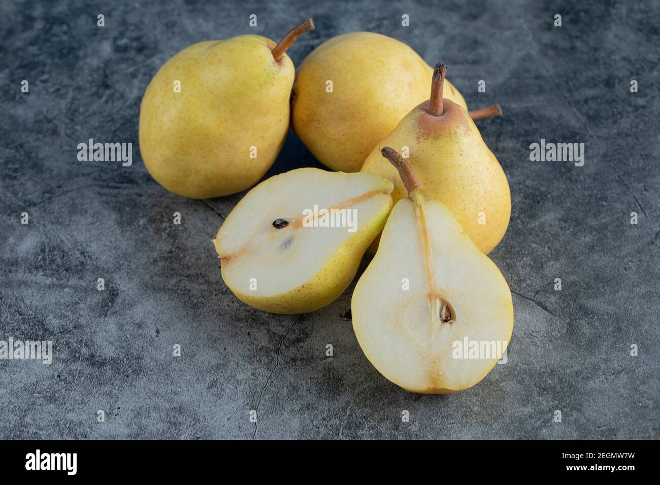 Whole and half cut yellow pears on the grey marble background Stock ...