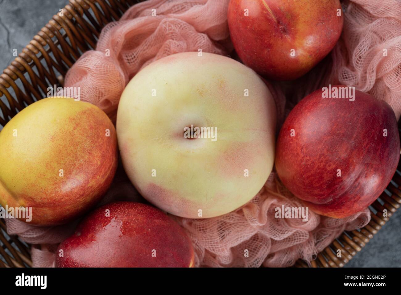 Wooden fruit basket with apples and red peaches Stock Photo - Alamy