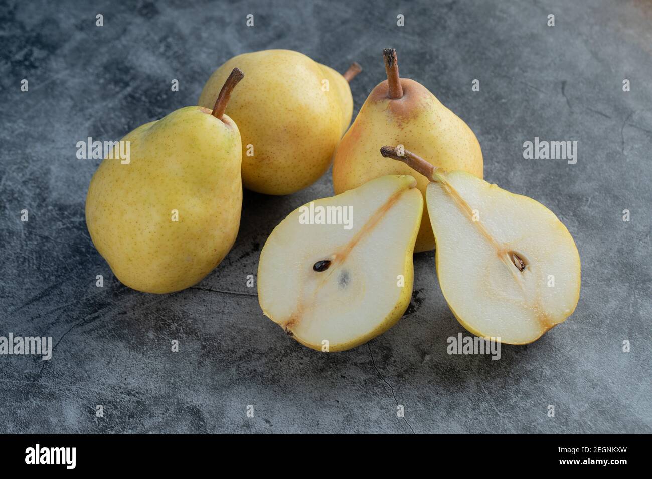 Whole and half cut yellow pears on the grey marble background Stock ...
