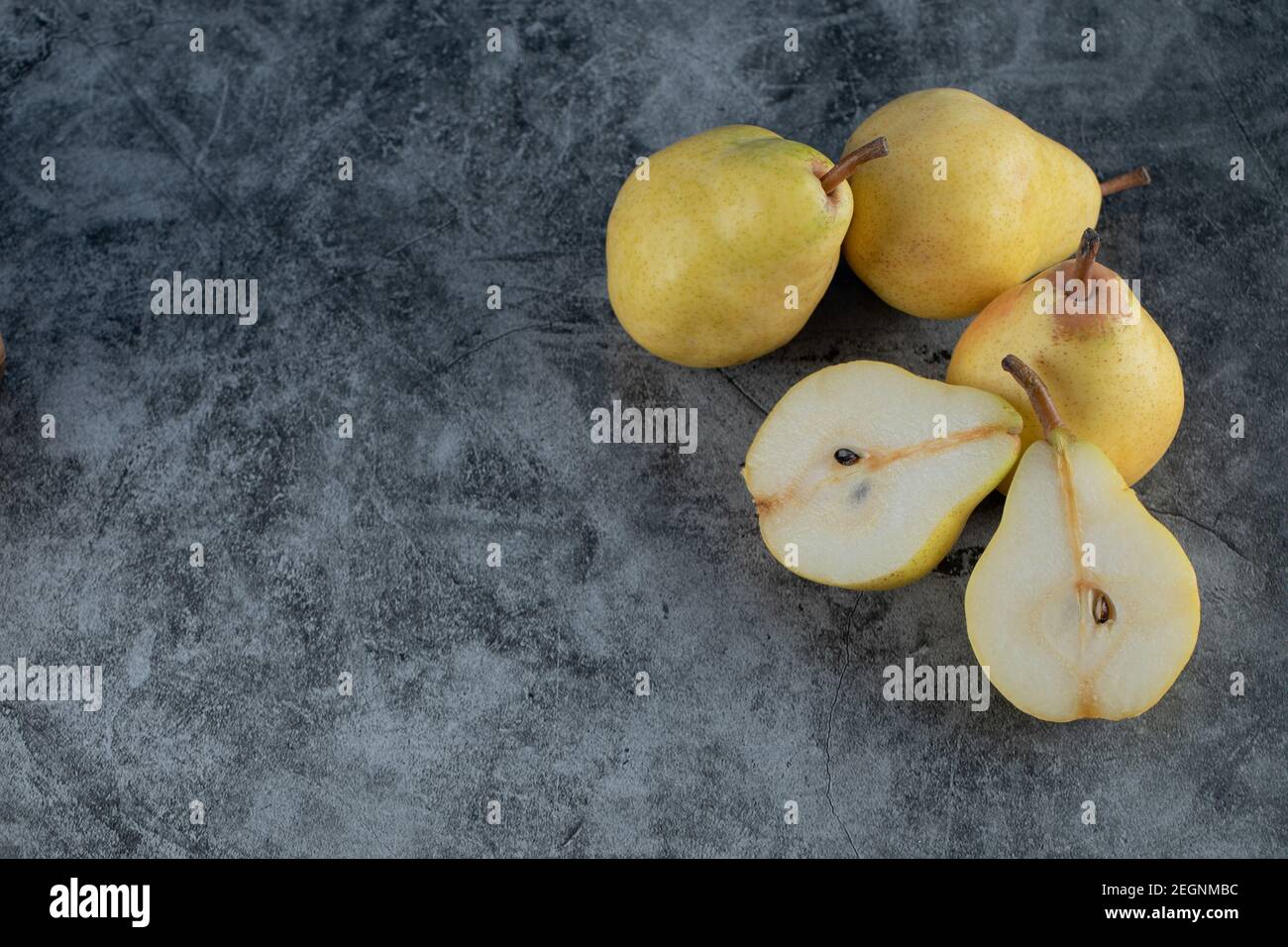 Whole and half cut yellow pears on the grey marble background Stock ...