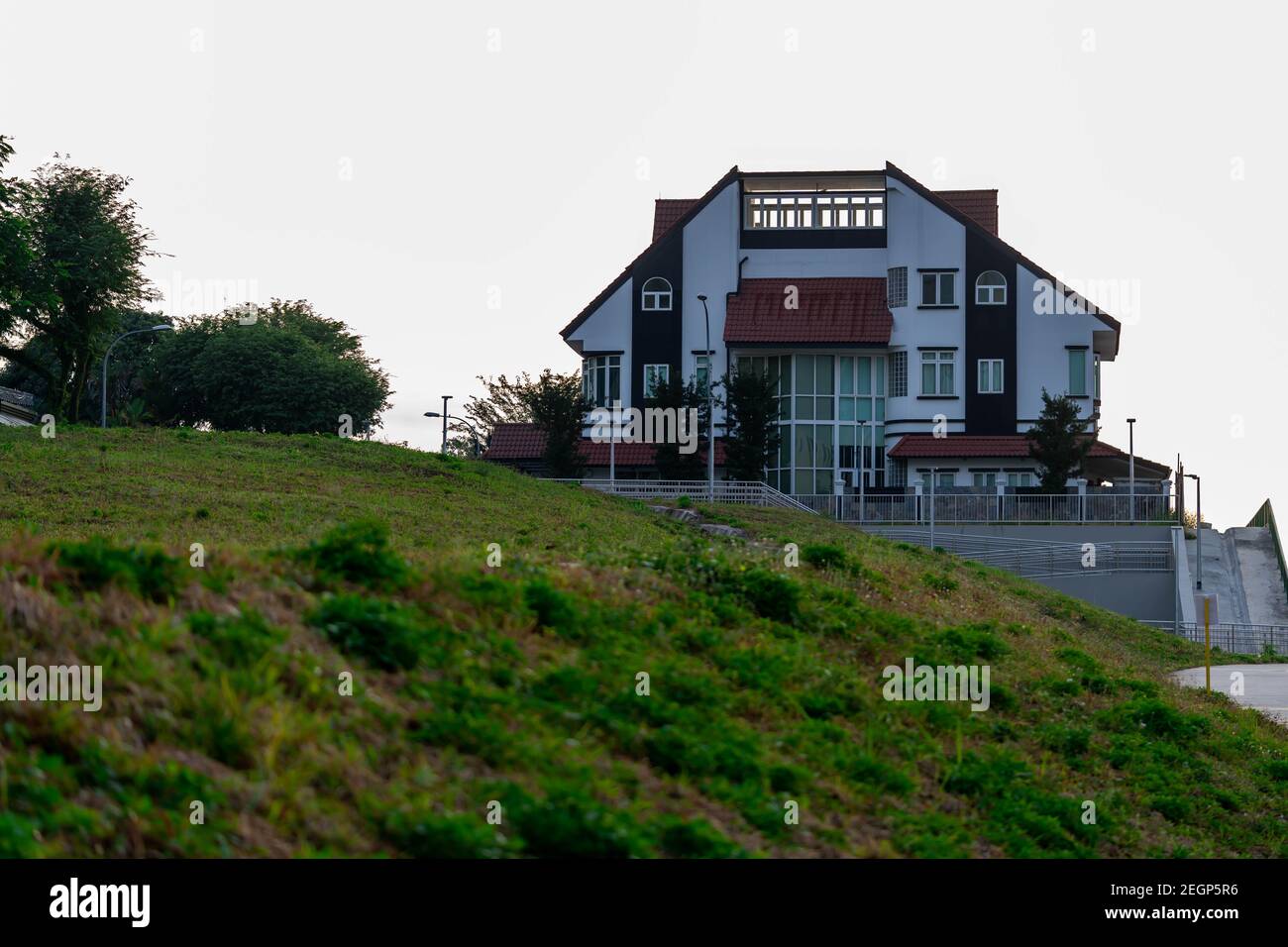 Modern house on a valley or hill covered with grass and trees Stock ...