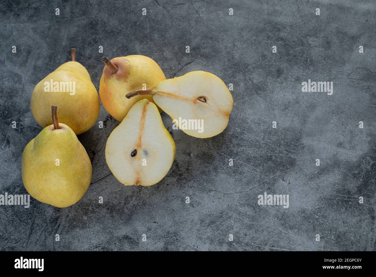 Whole and half cut yellow pears on the grey marble background Stock ...