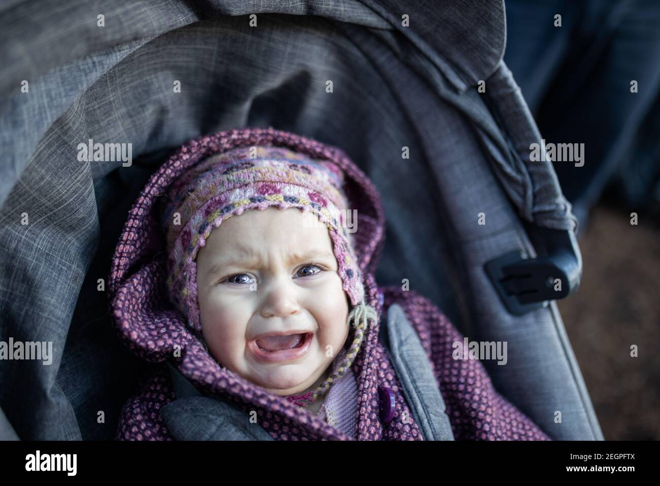 Adorable crying baby in a stroller with blurry background Stock Photo ...